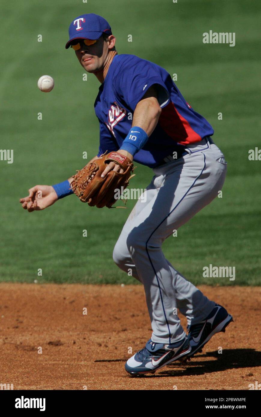 Texas Rangers shortstop Michael Young errors while trying to throw out ...