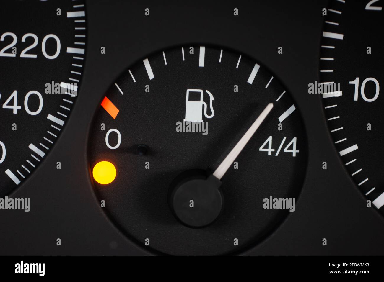 Car fuel gauge scale with orange reserve light on. Close up macro shot ...