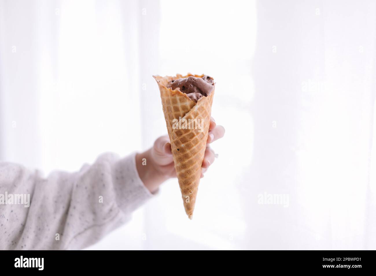 Hand holding waffle cone with chocolate ice cream, inside Stock Photo ...