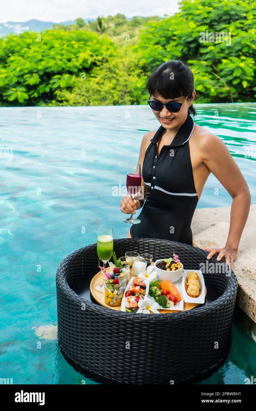 beautiful woman enjoys a floating breakfast in Thailand Stock Photo - Alamy