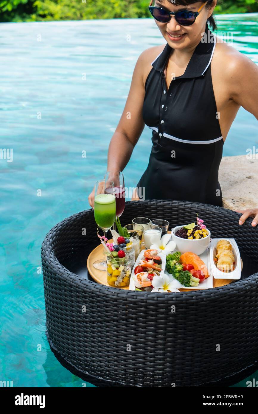 beautiful woman enjoys a floating breakfast in Thailand Stock Photo - Alamy