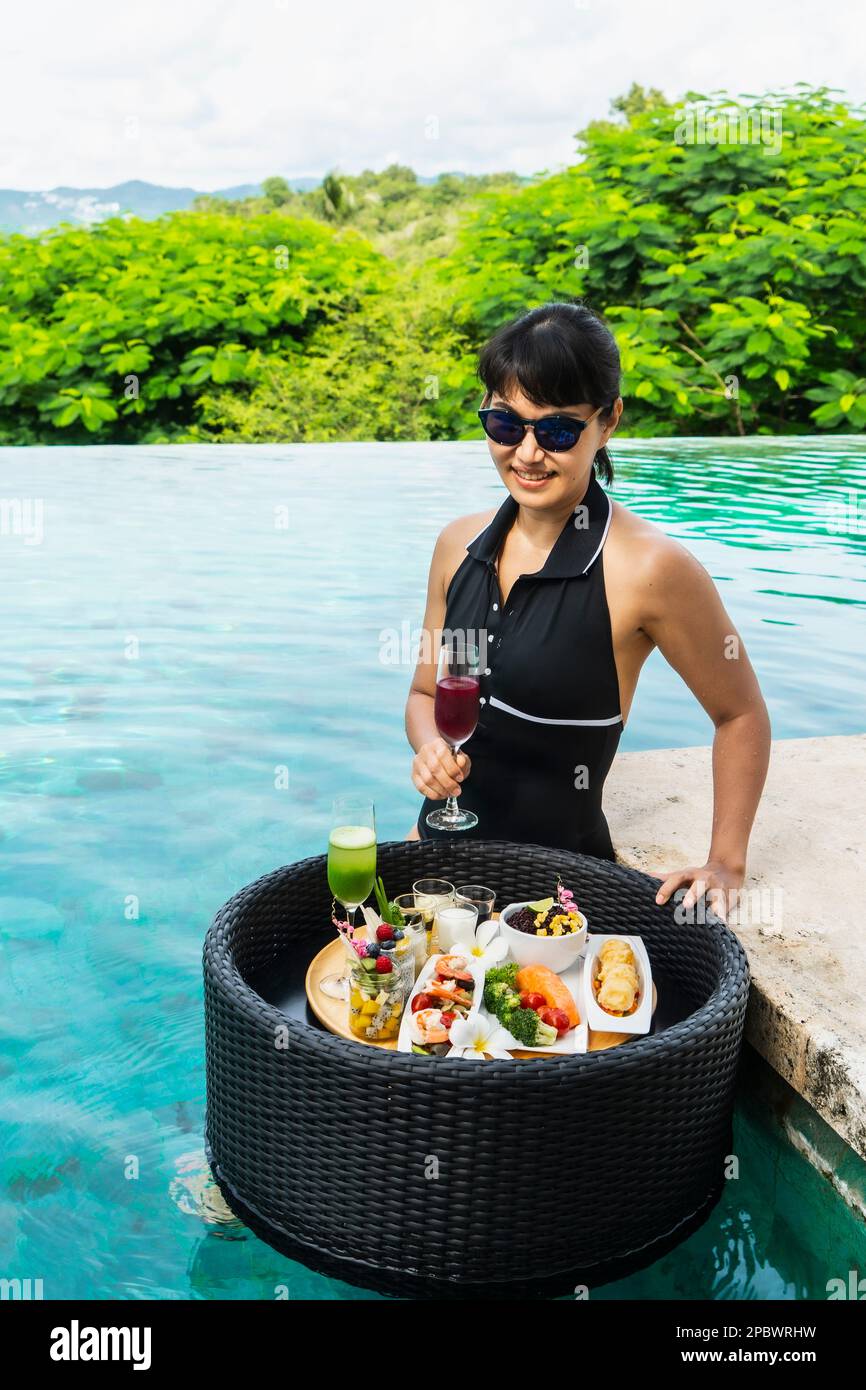 beautiful woman enjoys a floating breakfast in Thailand Stock Photo - Alamy