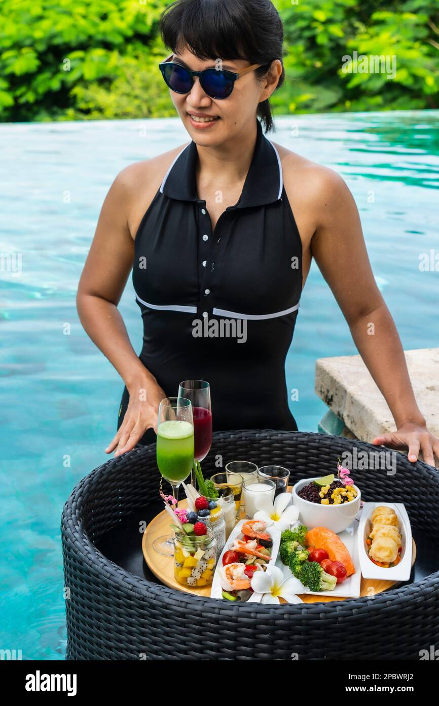 beautiful woman enjoys a floating breakfast in Thailand Stock Photo - Alamy