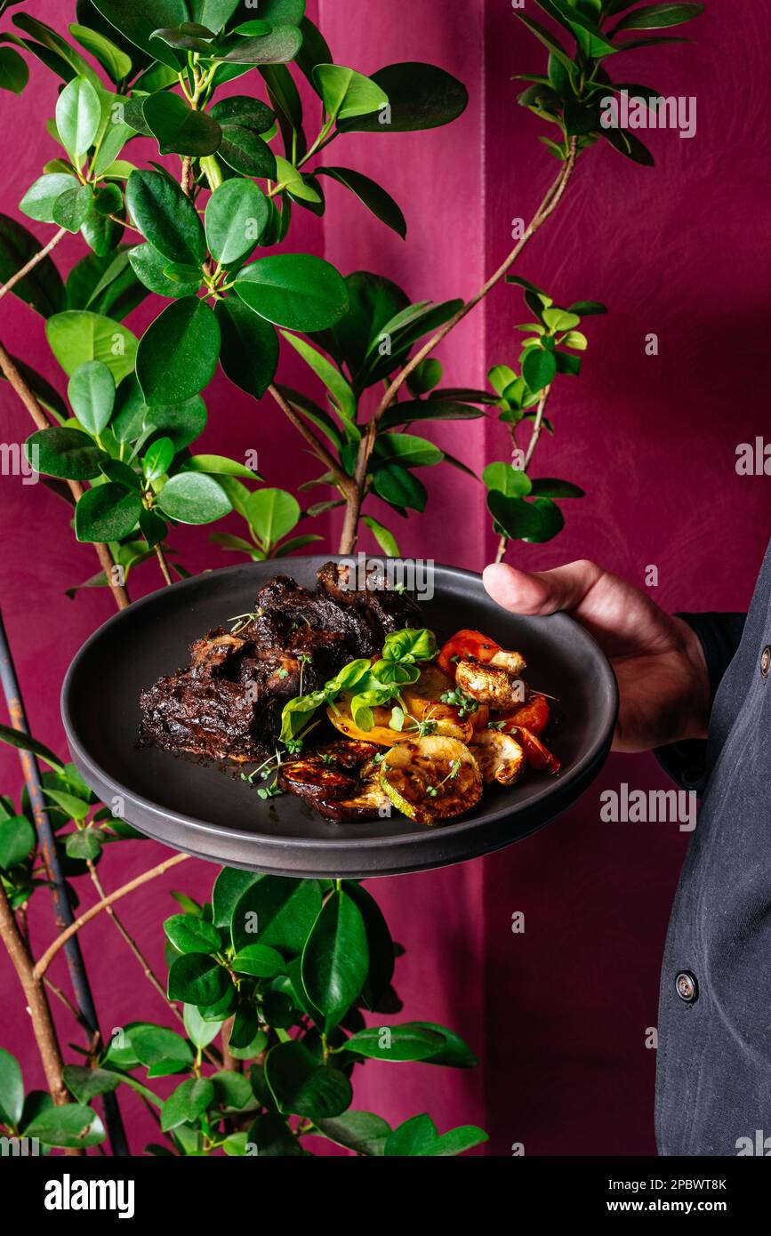 a man eats grilled beef in bbq sauce Stock Photo - Alamy