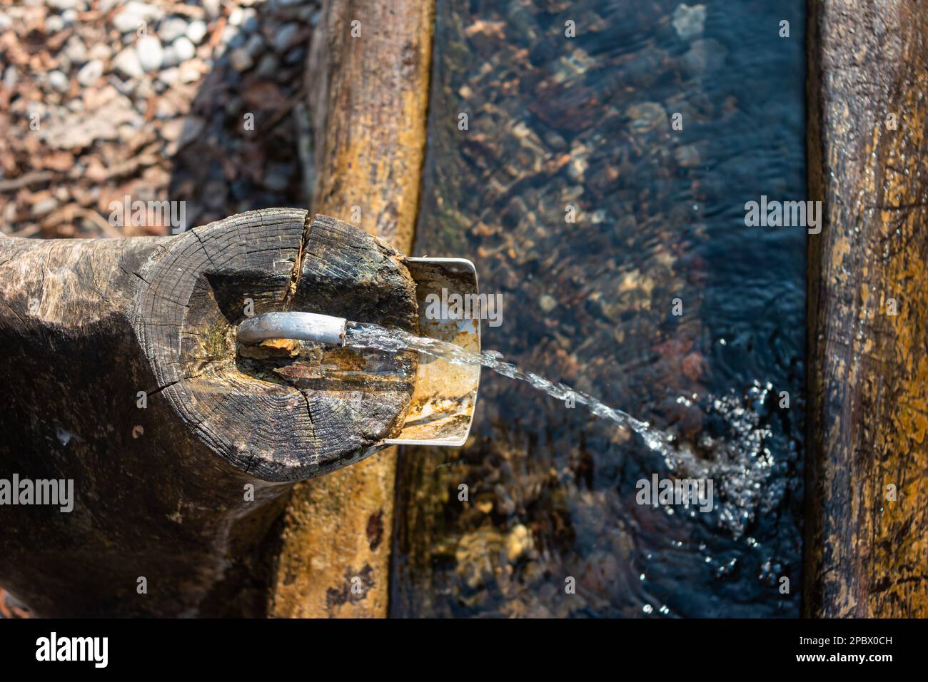 Old rustic drinking water fountain in the forest. Wooden construction ...