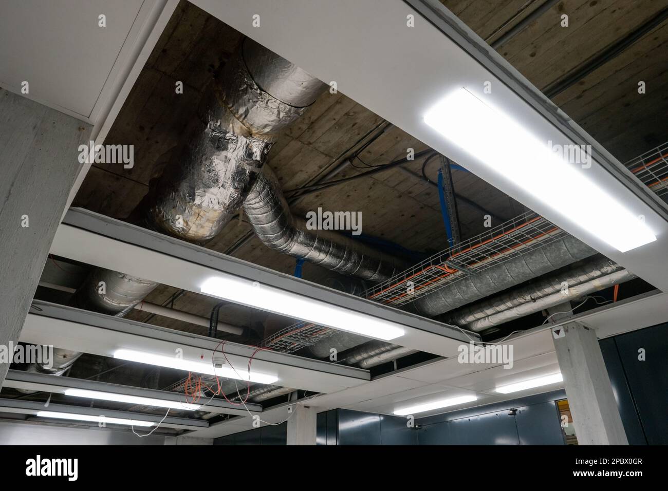 Large pipes mounted on the ceiling of an industrial building corridor ...
