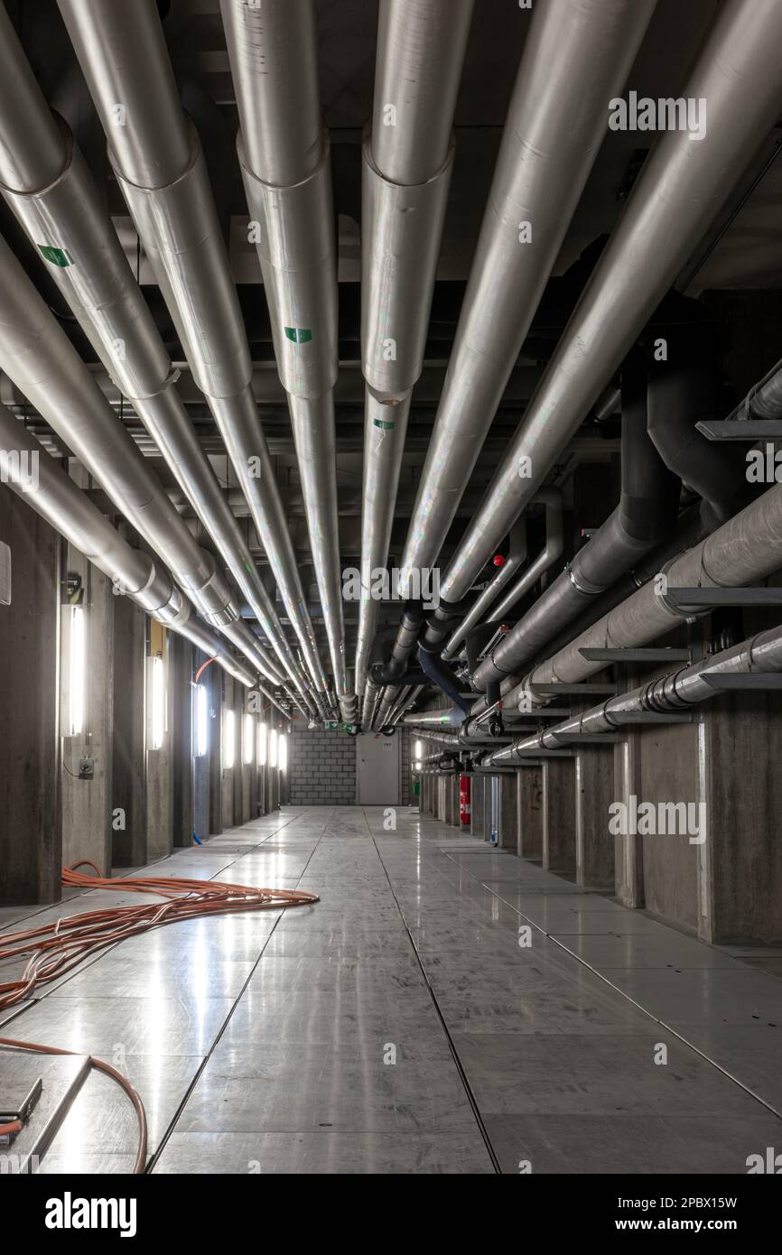 Ceiling mounted industrial pipelines inside underground building, Long ...
