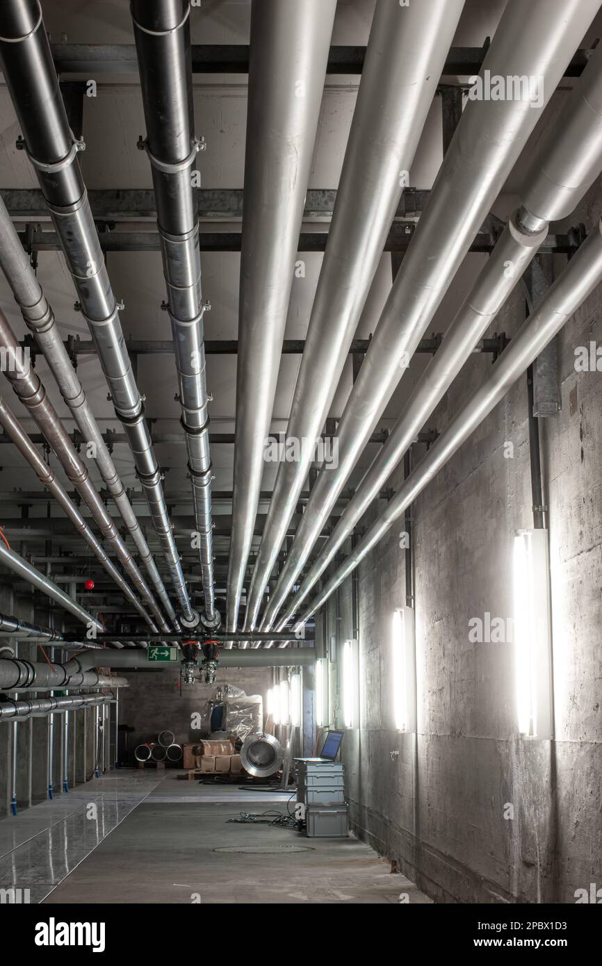 Ceiling mounted industrial pipelines inside underground building, Long ...