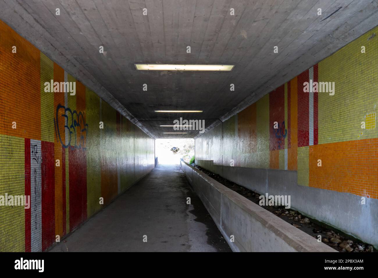 Urban underpass corridor with colored ceramic tiles mosaic and neon ...