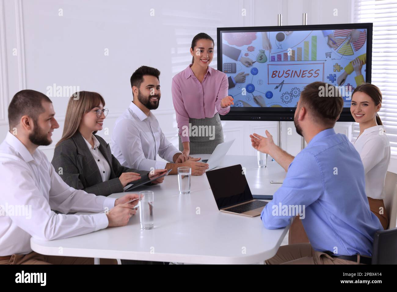 Business trainer near interactive board in meeting room during ...