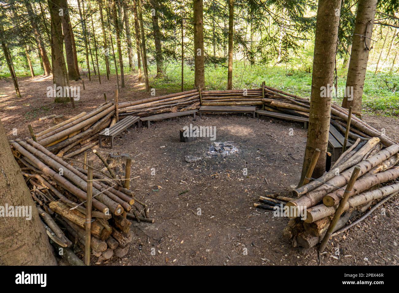 Empty picnic spot in a forest in Europe. Fire place with charred wood ...