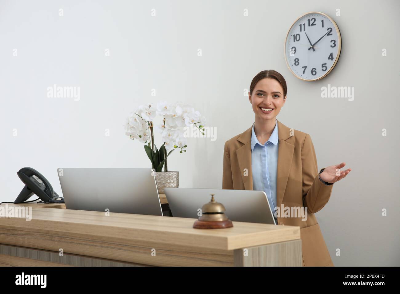 Portrait of beautiful receptionist at counter in hotel Stock Photo - Alamy