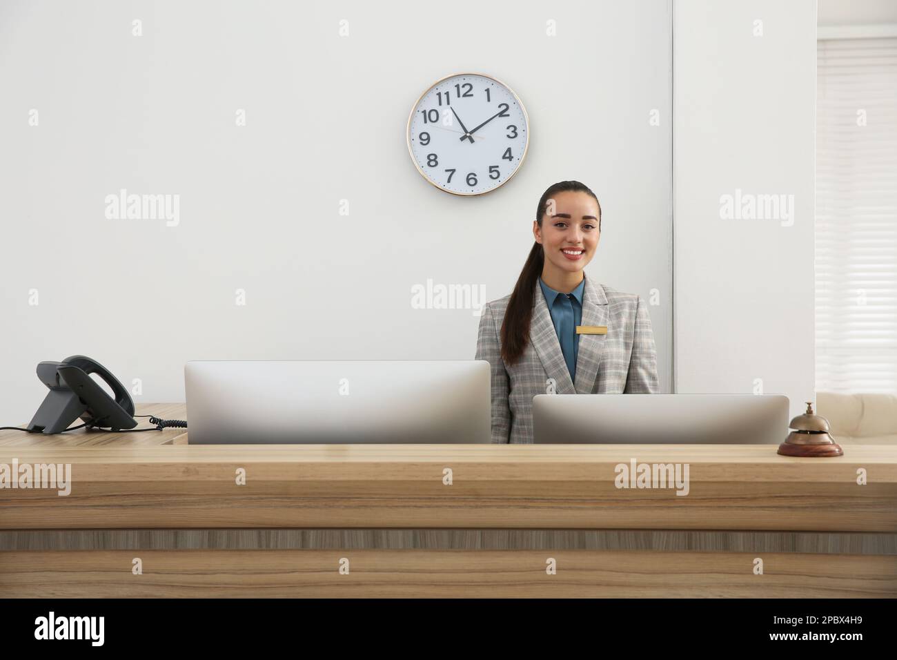 Portrait of beautiful receptionist at counter in hotel Stock Photo - Alamy