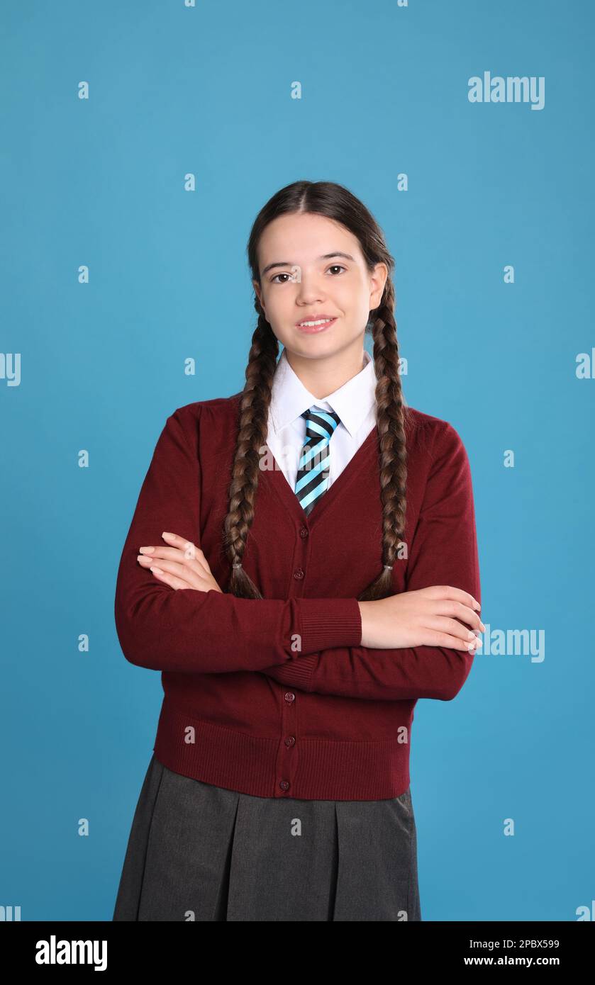 Teenage girl wearing school uniform on light blue background Stock ...