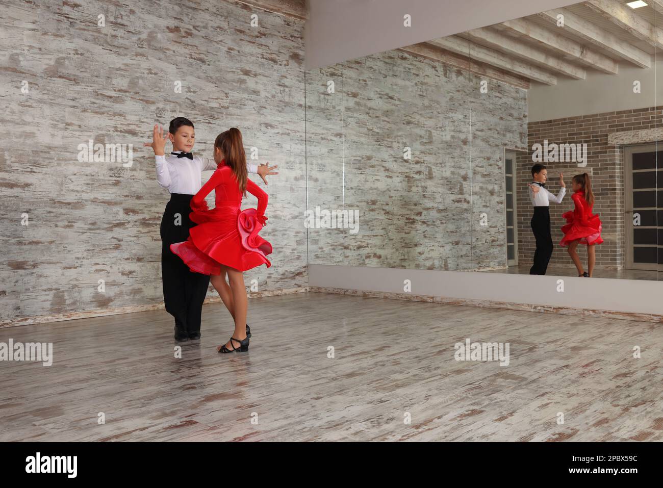 Beautifully dressed couple of kids dancing together in studio, space ...