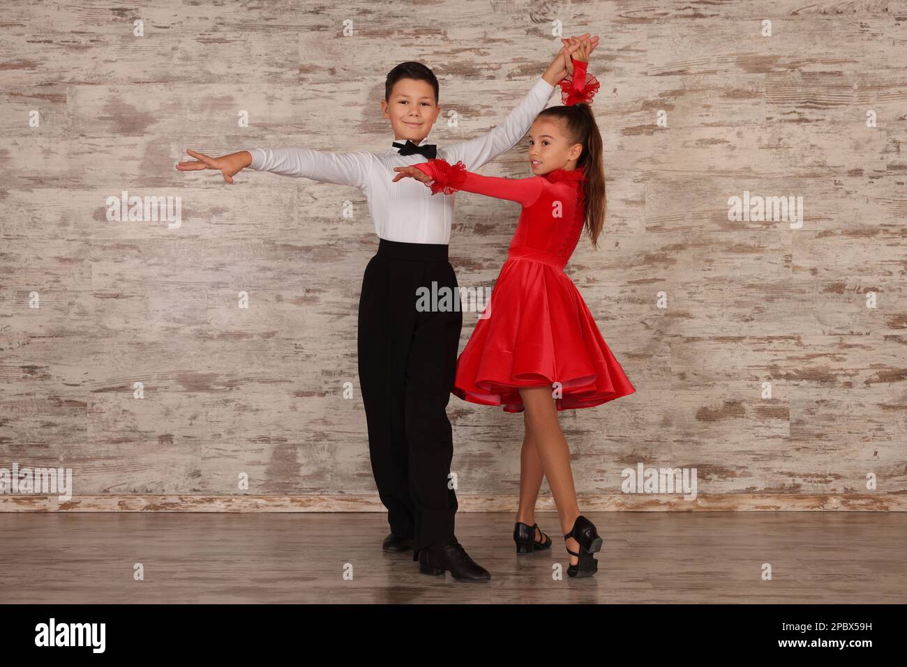 Beautifully dressed couple of kids dancing together in studio Stock ...