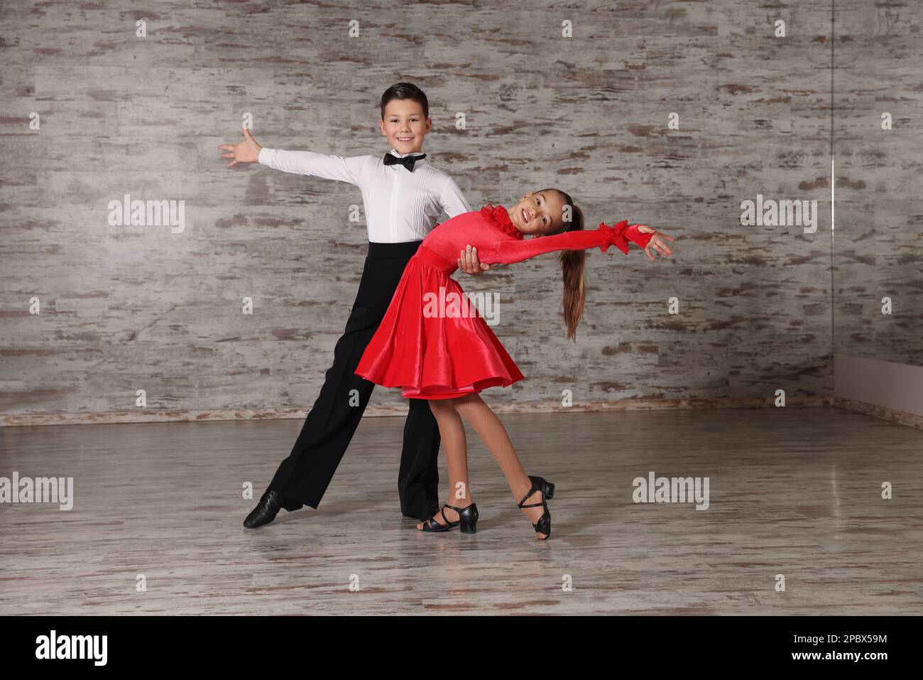 Beautifully dressed couple of kids dancing together in studio Stock ...