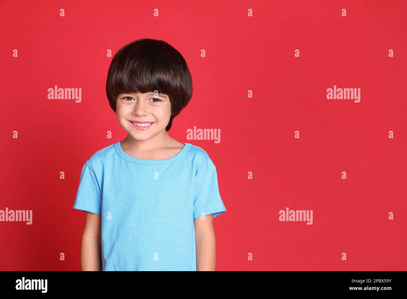 Portrait of cute little boy on red background, space for text Stock ...