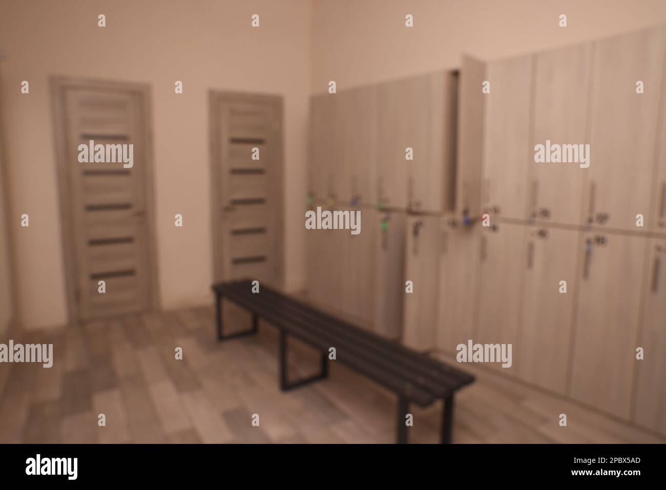 Blurred view of changing room with bench and lockers Stock Photo - Alamy