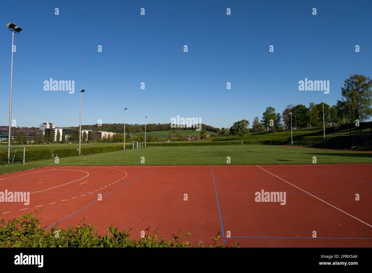 School empty soccer field near a forest in the hills. Daytime, blue sky ...