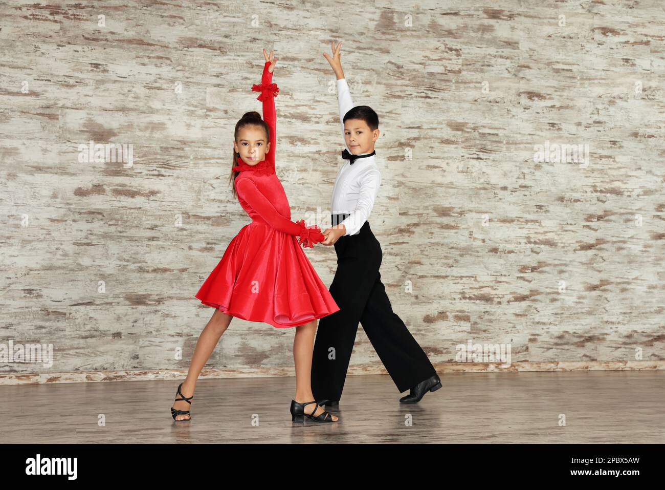 Beautifully dressed couple of kids dancing together in studio Stock ...