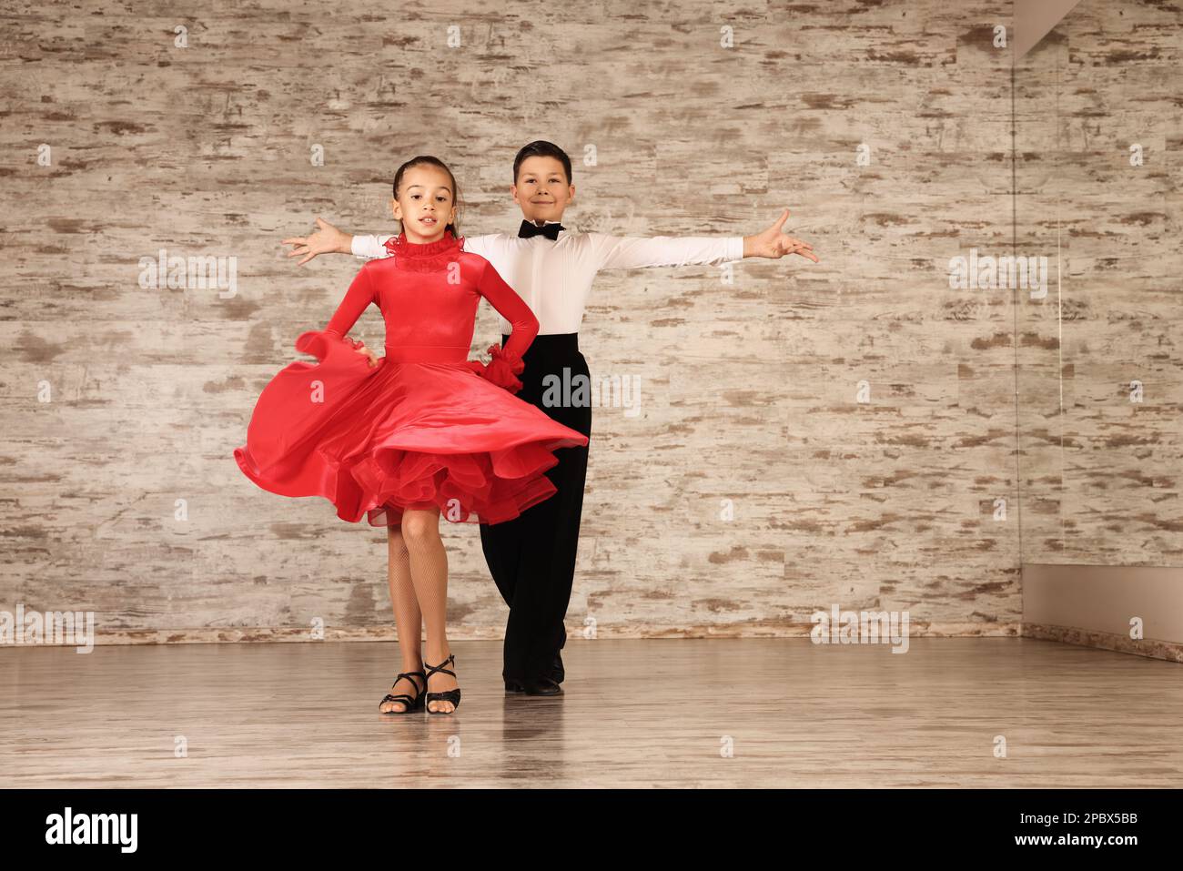 Beautifully dressed couple of kids dancing together in studio Stock ...