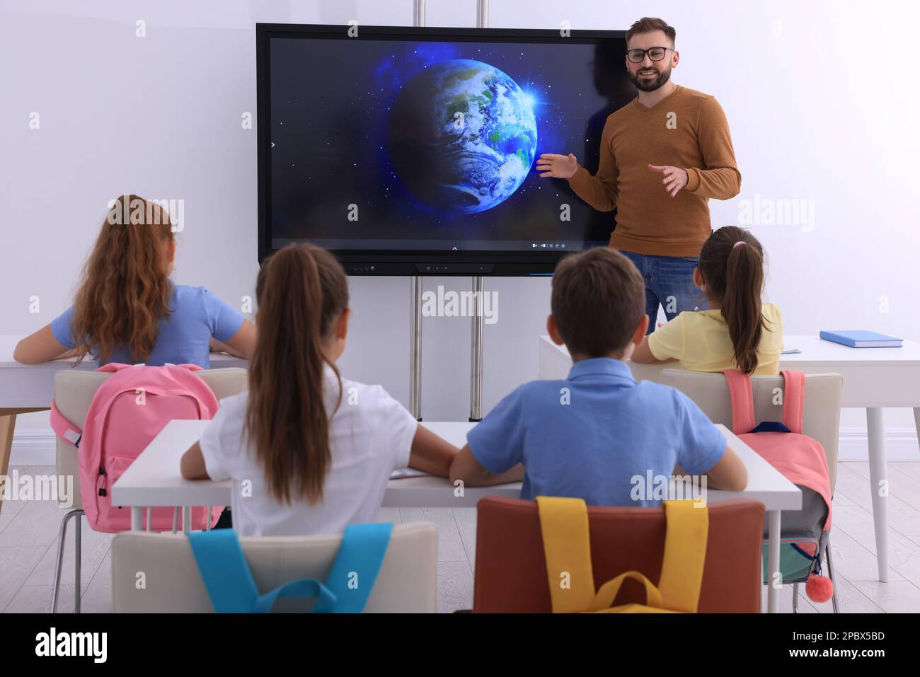 Teacher near interactive board in classroom during lesson Stock Photo ...
