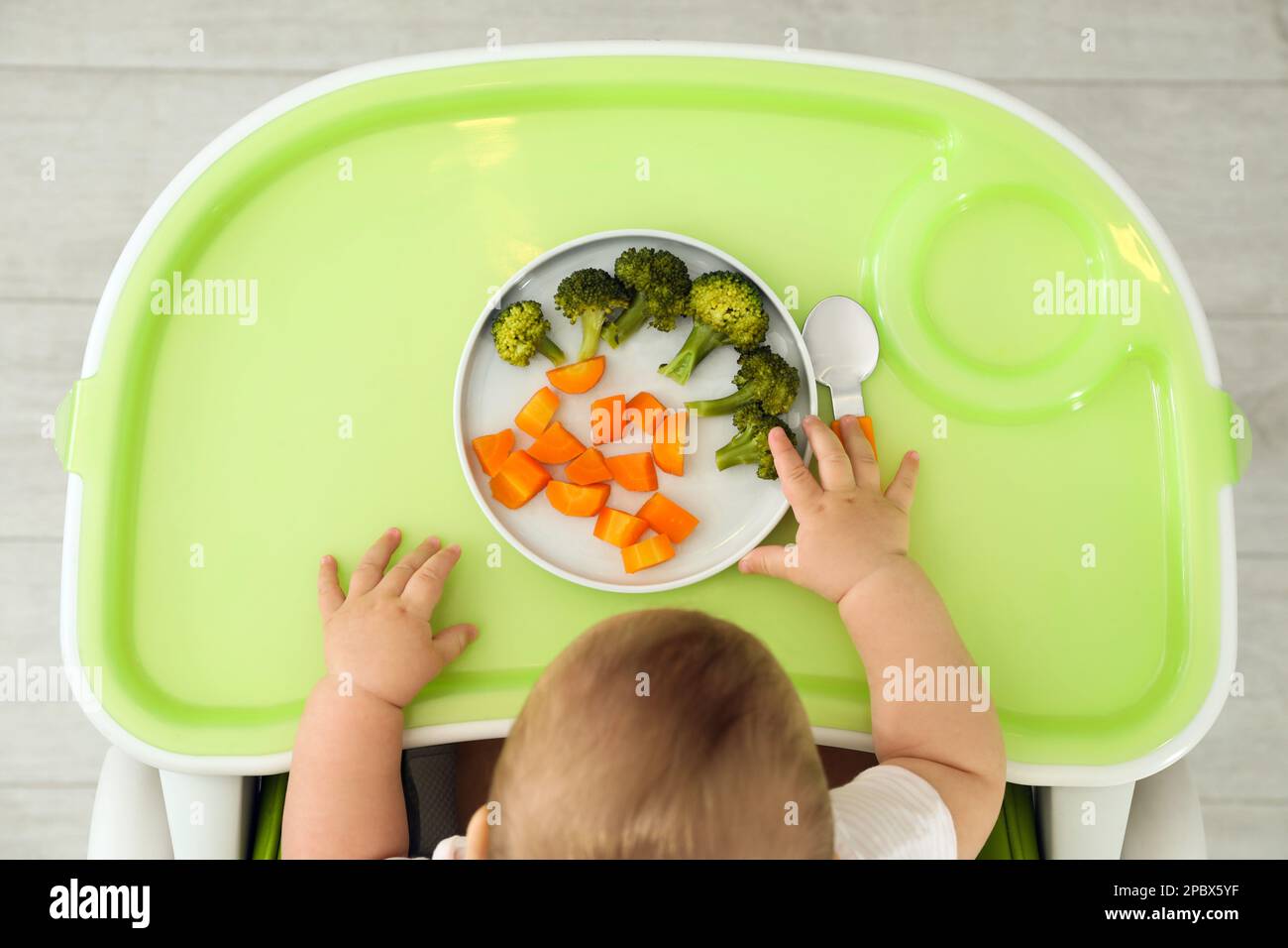 Cute little baby eating healthy food, top view Stock Photo - Alamy