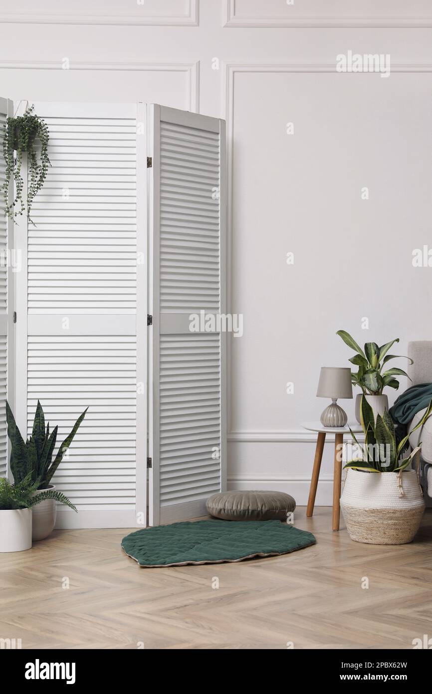 Stylish room with folding screen and floral decor. Interior design ...