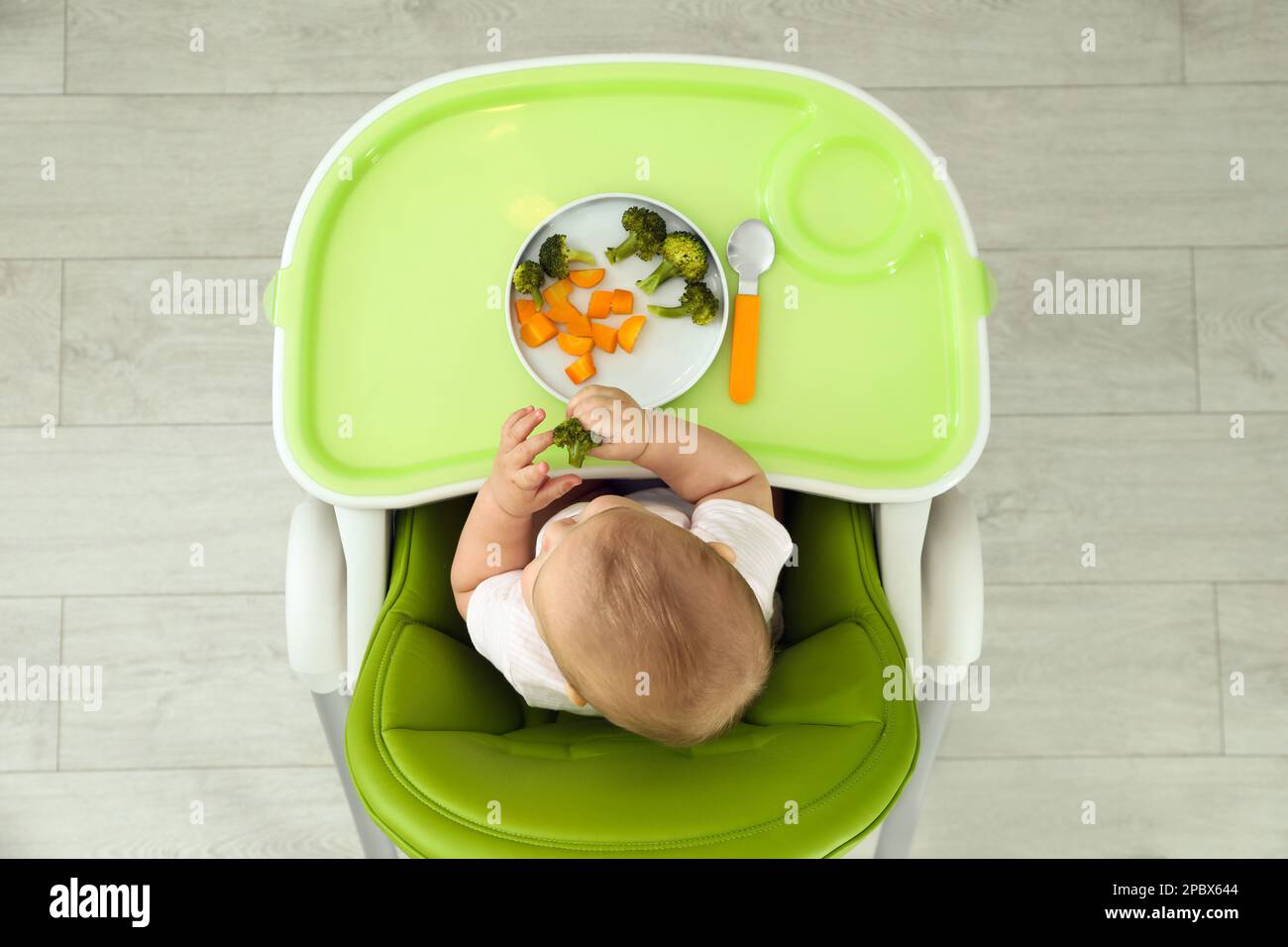 Cute little baby eating healthy food, top view Stock Photo - Alamy