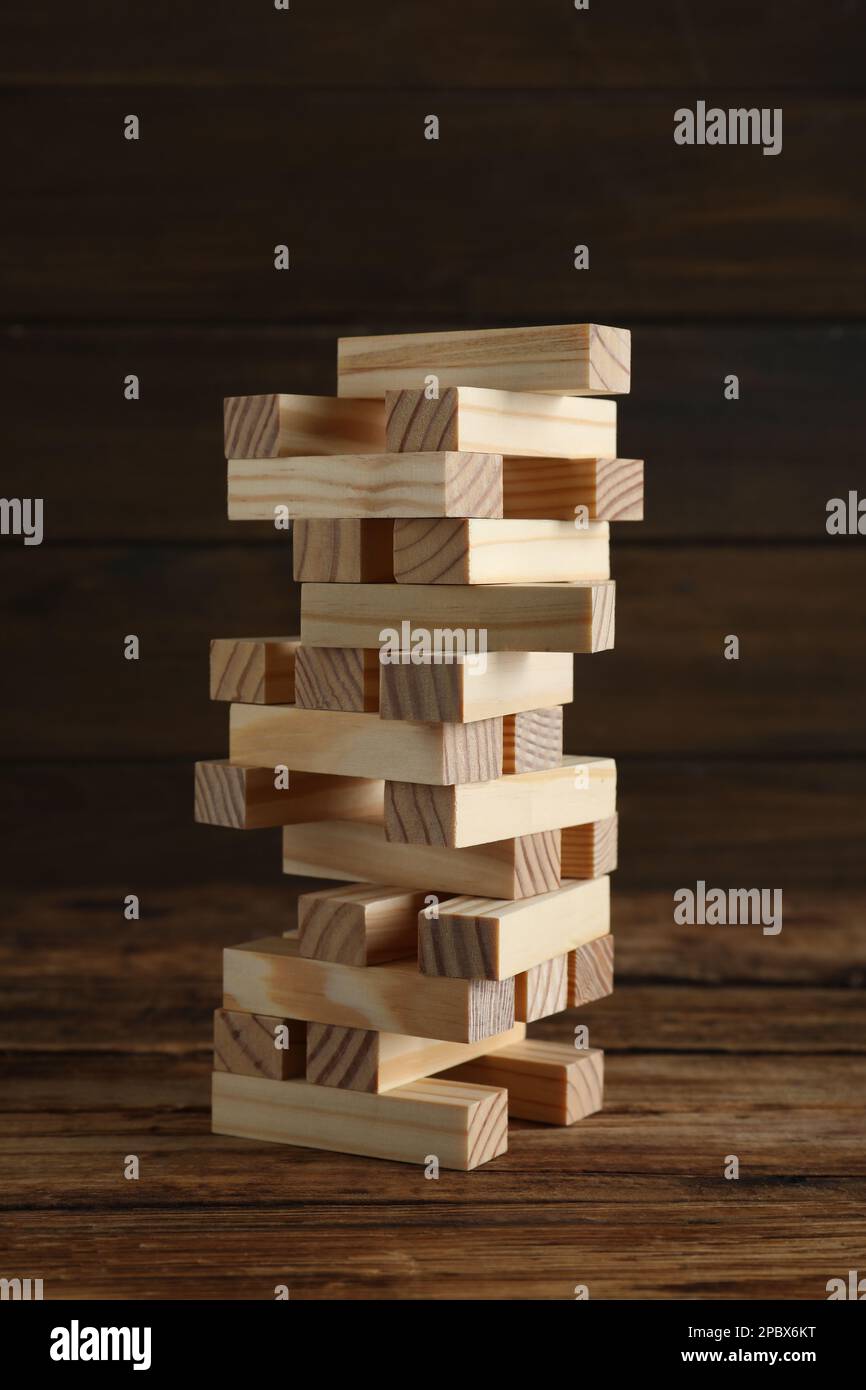 Jenga tower made of wooden blocks on table Stock Photo - Alamy