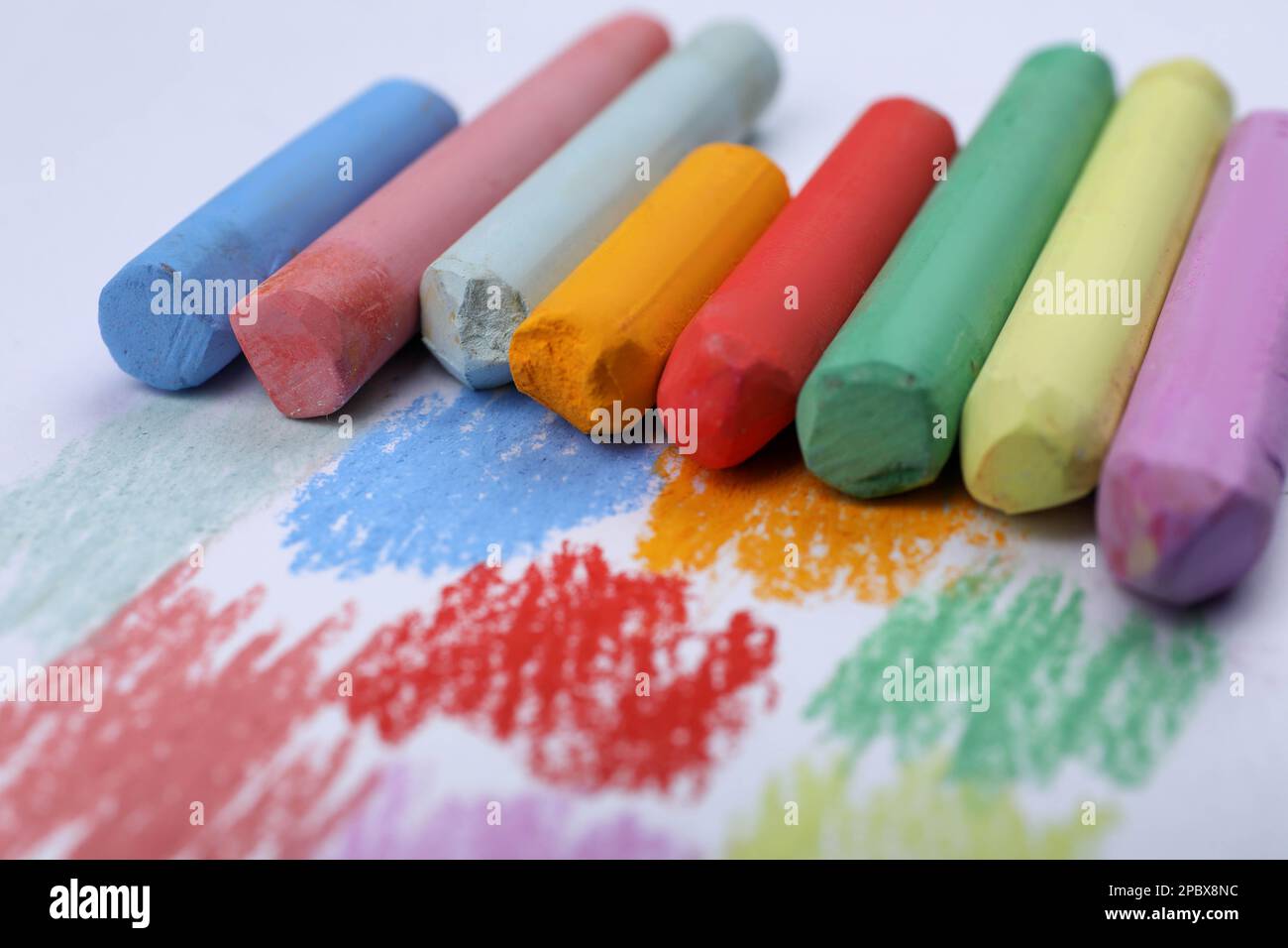 Colorful pastel chalks and scribbles on white background, closeup ...