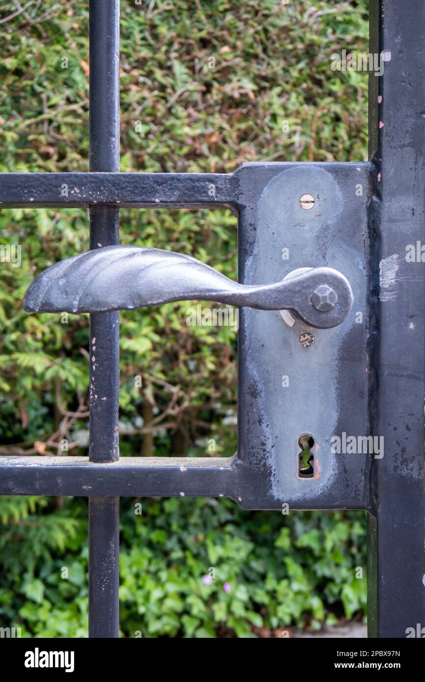 Old weathered vintage forged metal gate lock with green defocused ...