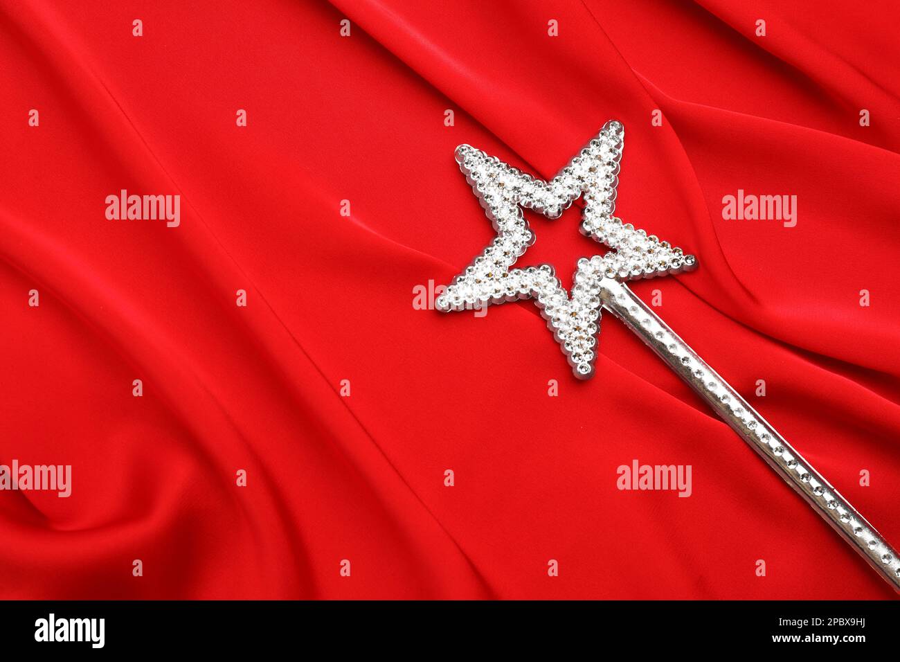 Beautiful silver magic wand on red fabric. Space for text Stock Photo ...