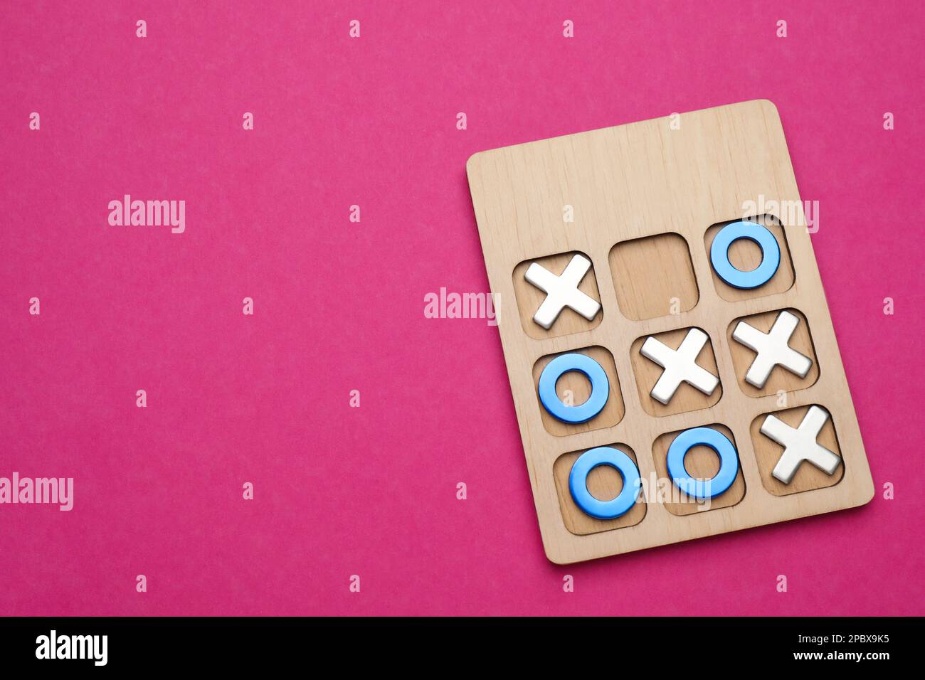 Tic tac toe set on bright pink background, top view. Space for text ...