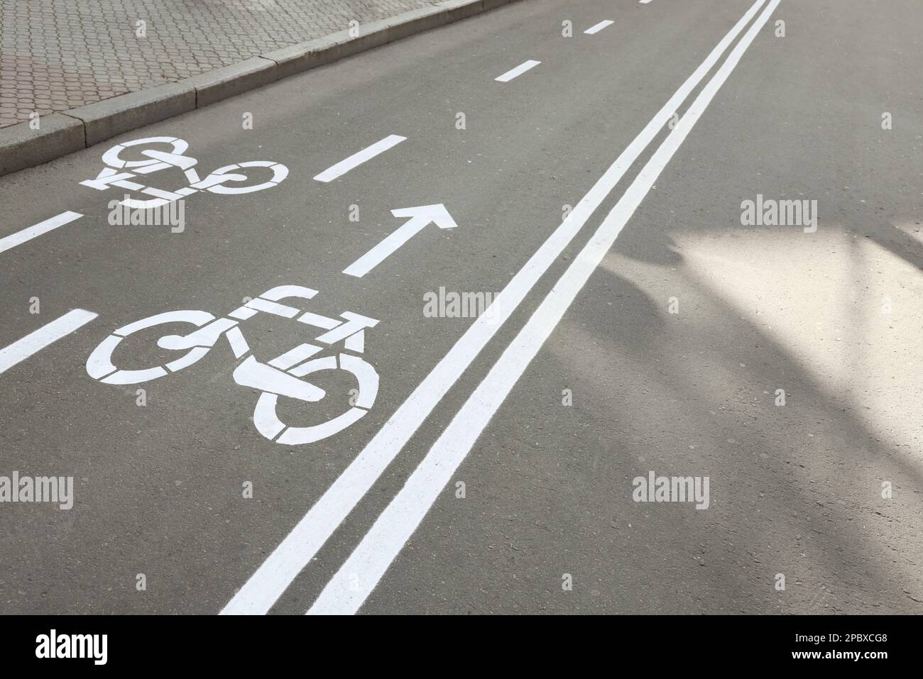 Two way bicycle lane with white signs on asphalt Stock Photo - Alamy