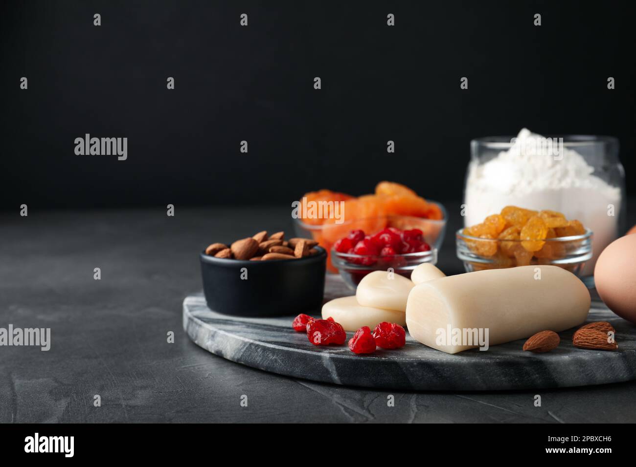 Marzipan and other ingredients for homemade Stollen on grey table ...