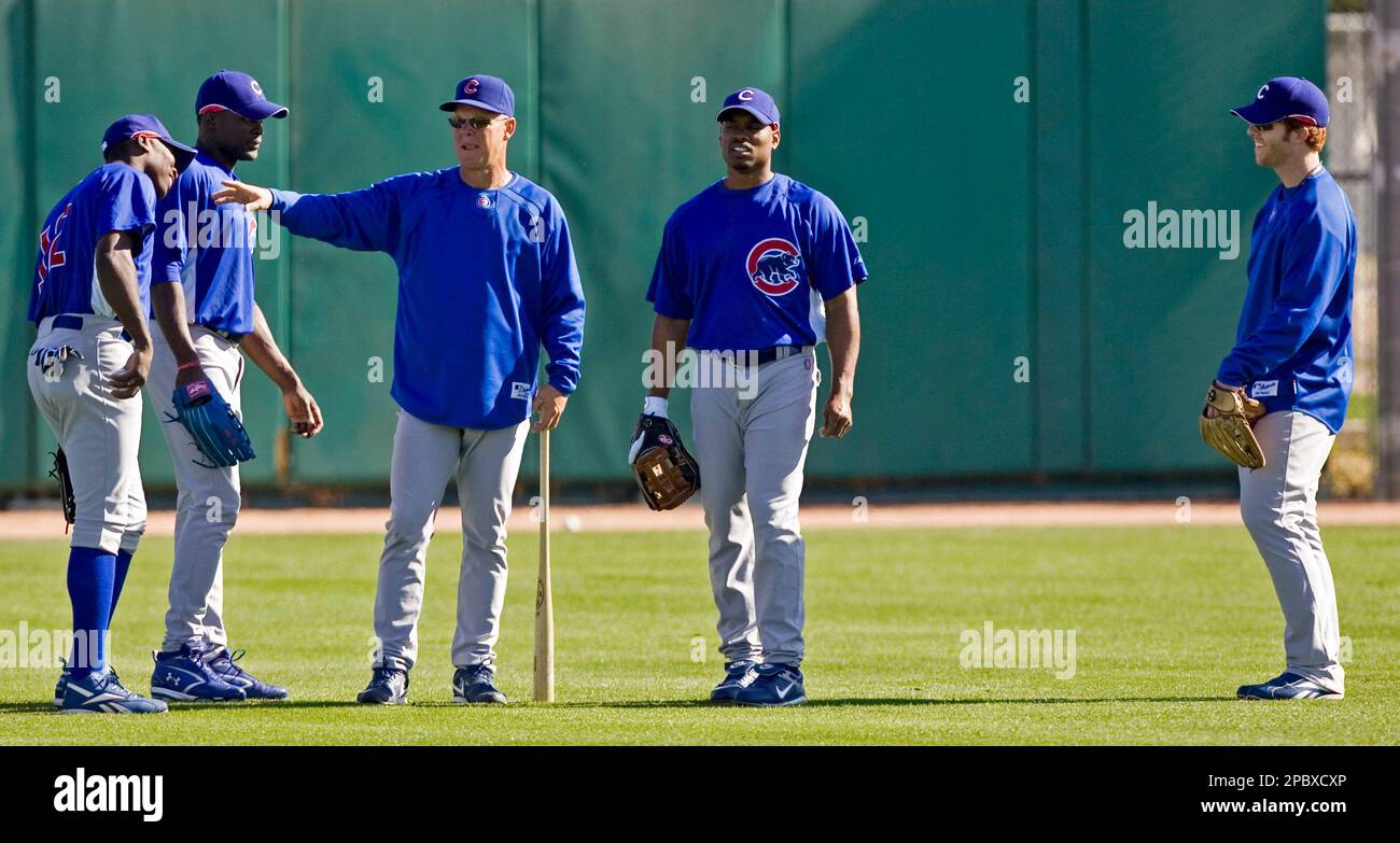 Chicago Cubs coach Mike Quade, holding bat, talks to outfielders, from ...