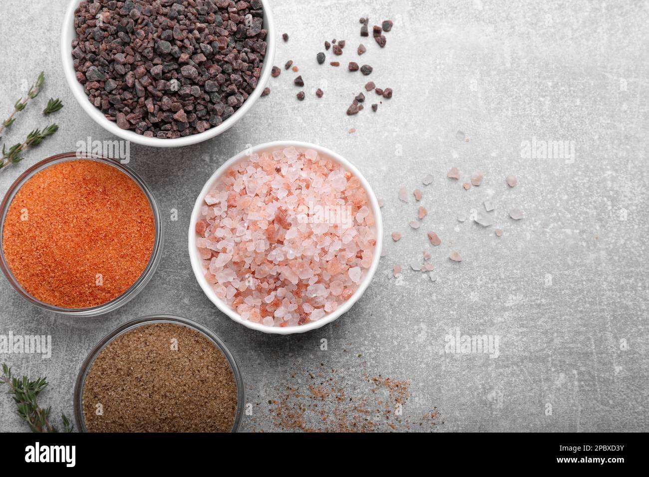 Different kinds of salt on grey table, flat lay. Space for text Stock ...