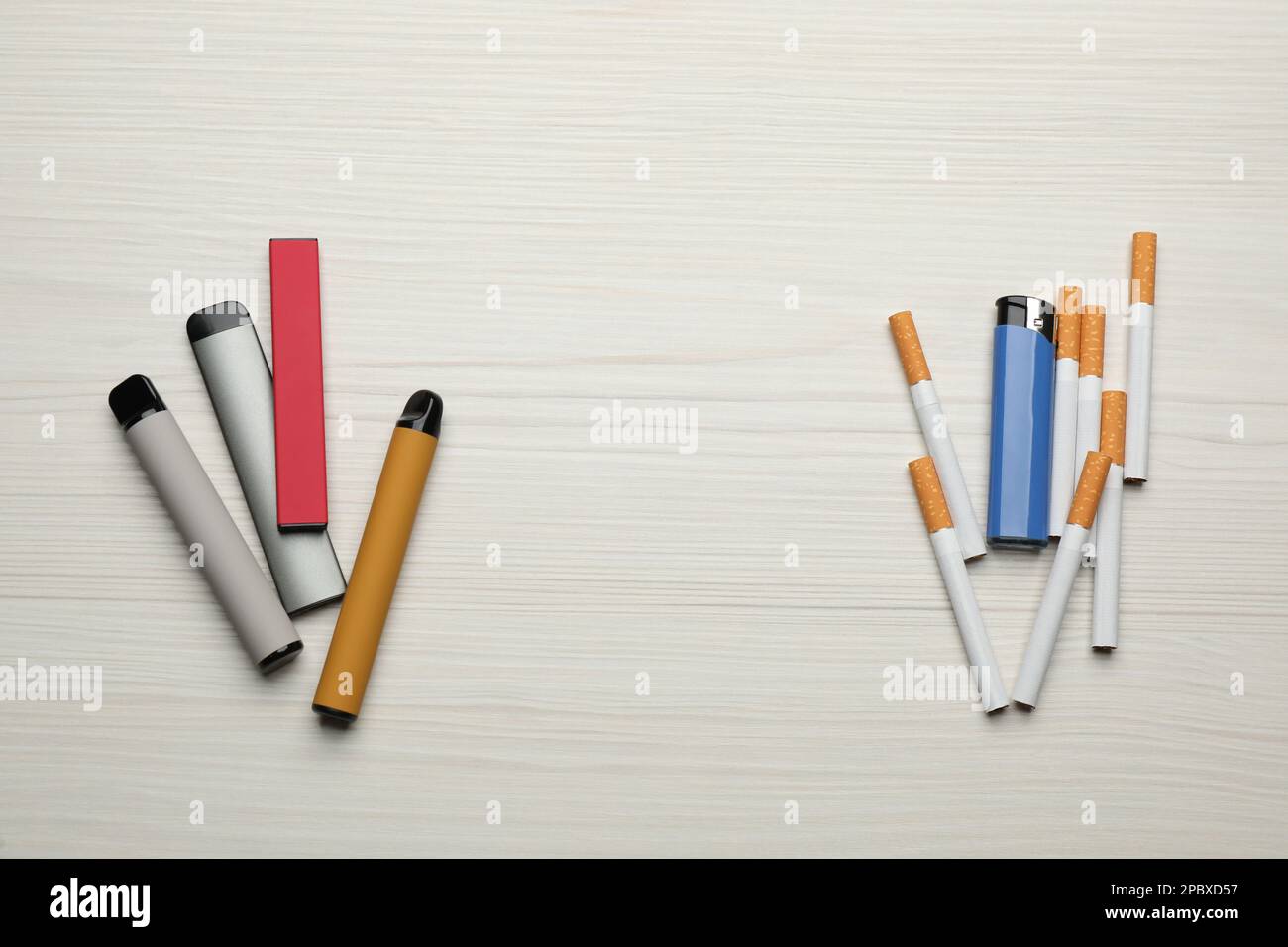 Cigarettes with lighter and different vaping devices on white wooden ...