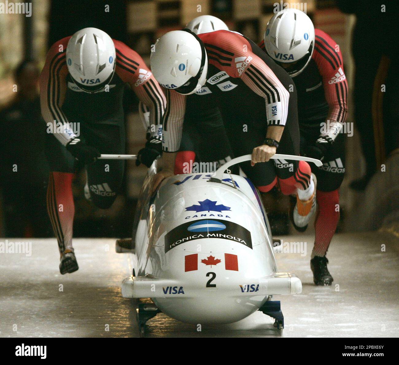 Canada's Pierre Lueders, center front, hops onto his sleigh as his ...