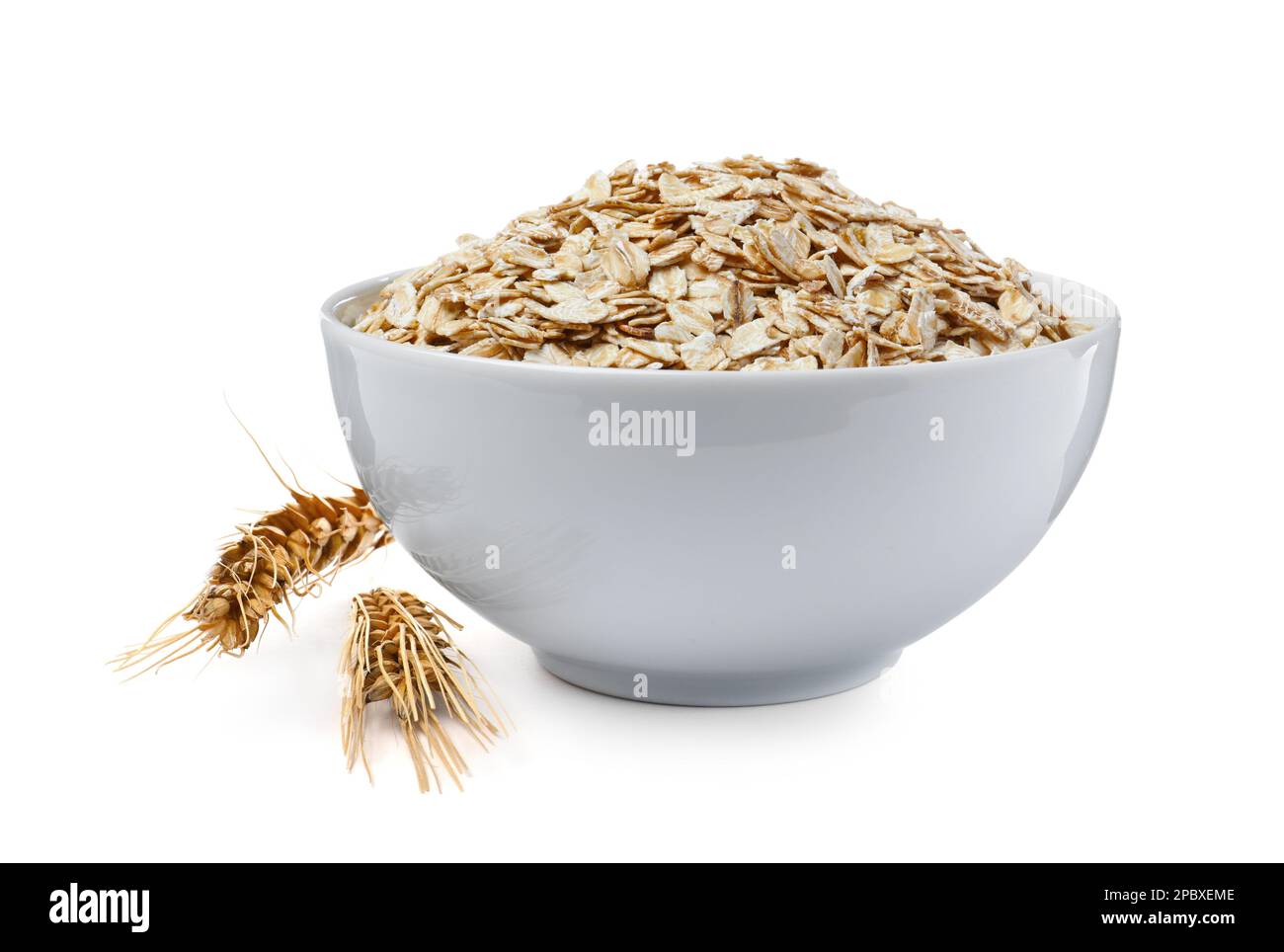 Raw oatmeal in bowl and spikelets on white background Stock Photo - Alamy