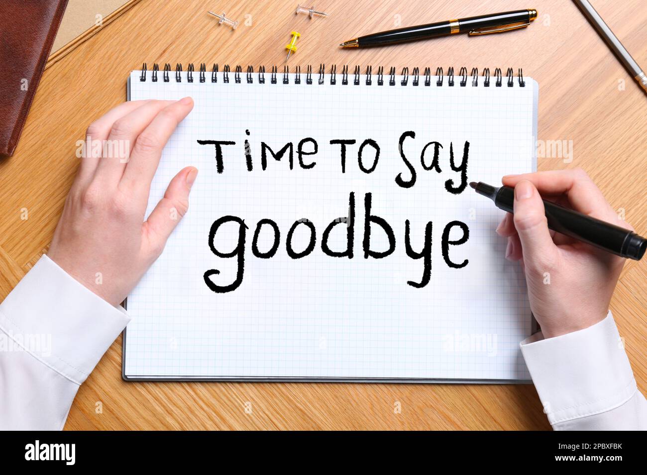 Woman writing phrase Time to say Goodbye at wooden table, top view ...