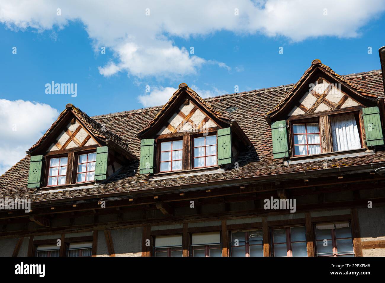 Old vintage European decorated attic windows with open wooden shutter ...