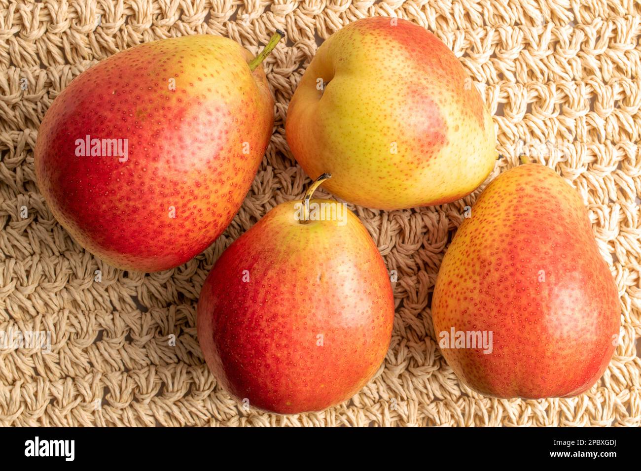 Four yellow pears, close-up, on a straw mat, top view Stock Photo - Alamy