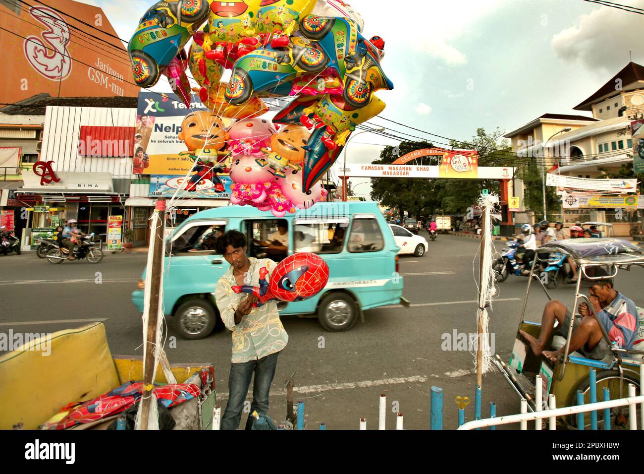 A mobile balloon vendor and a rickshaw driver in a background of road ...