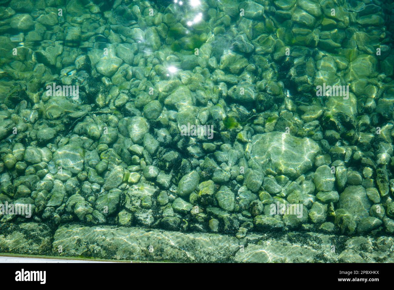 Underwater pebbles and rock on a shallow water riverbed, no people ...