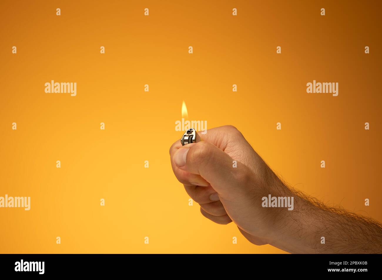 Lit cigarette lighter and flame held in hand by Caucasian male hand ...