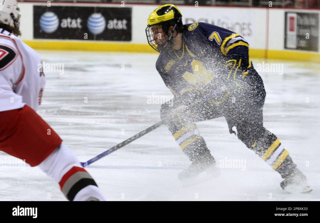 Michigan's T.J. Hensick (7) passes the puck during the first period of ...