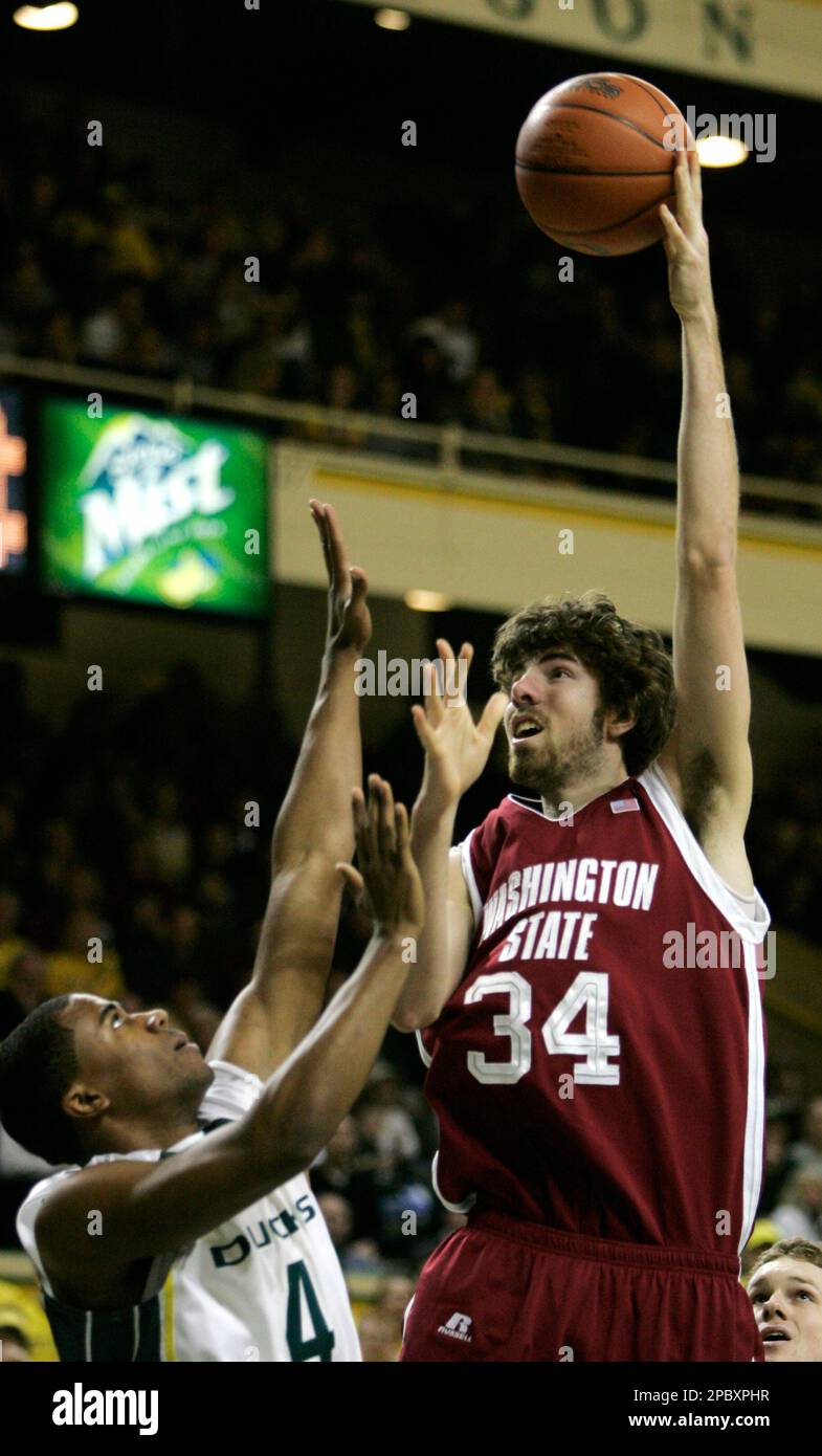 Washington State forward Robbie Cowgill, right, shoots a hook shot over ...